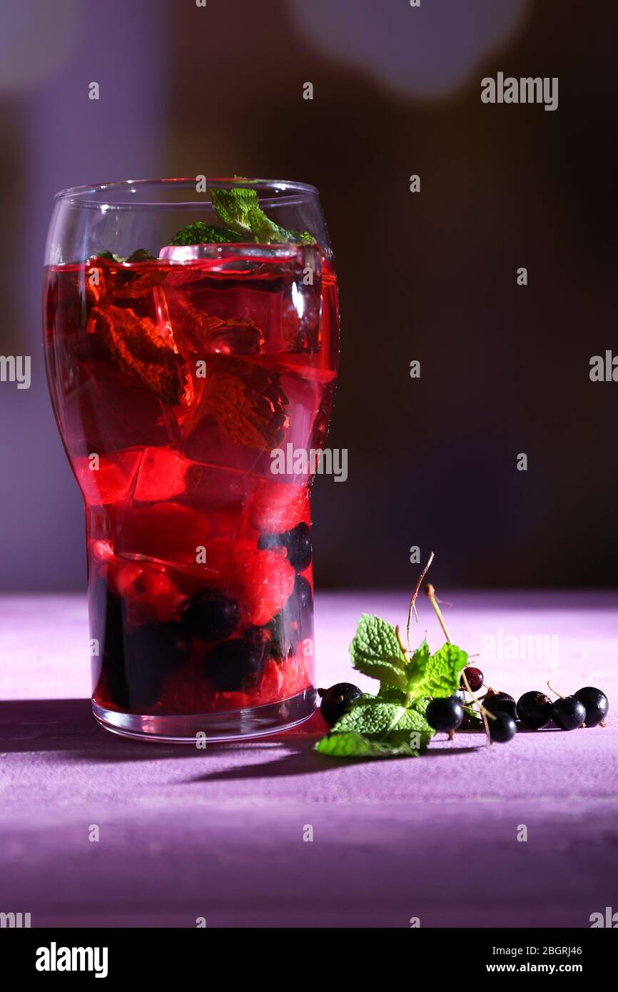 Glass of cold berry cocktail on wooden table Stock Photo - Alamy