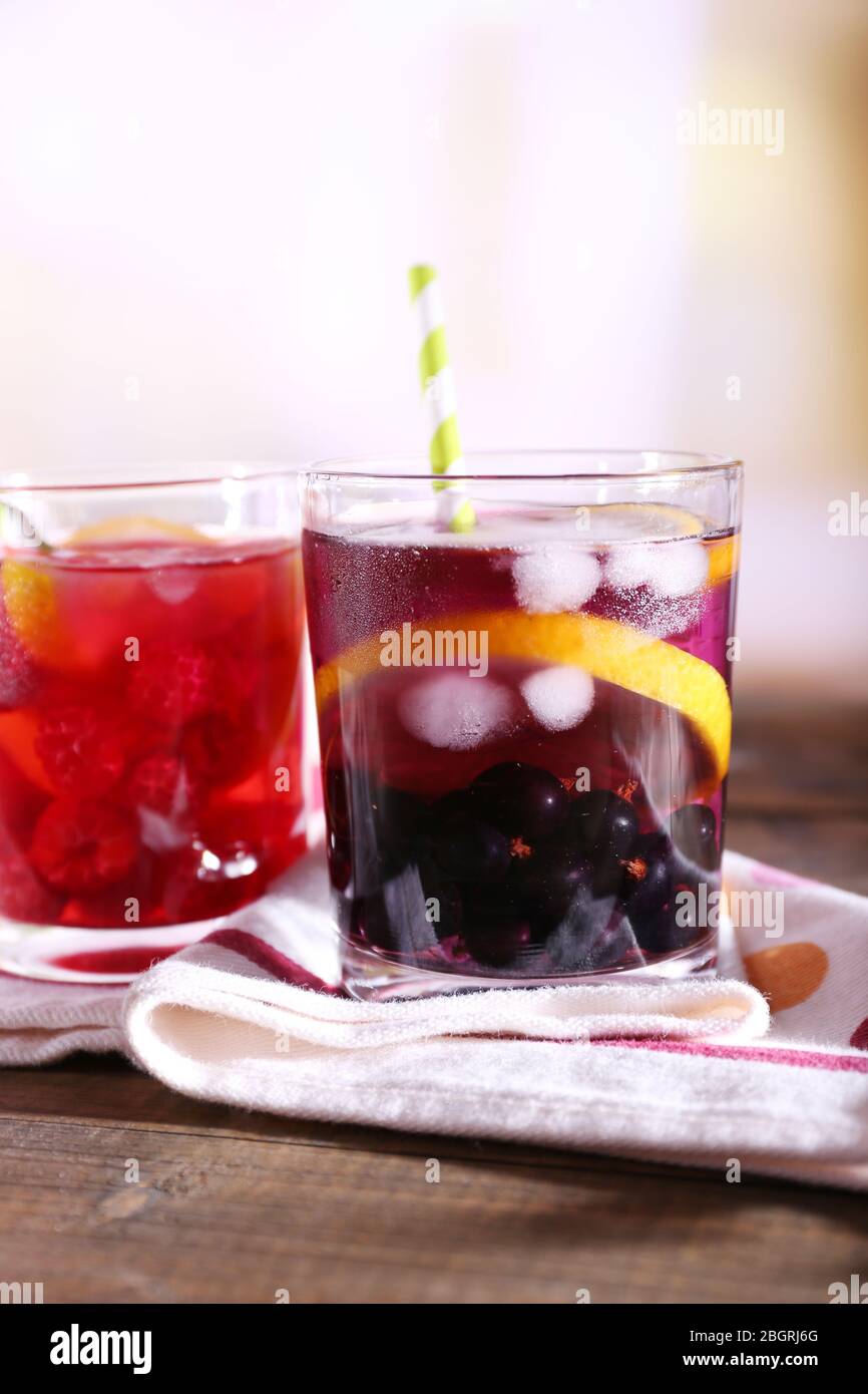 Glasses of cold berry cocktail with lemon on wooden table Stock Photo ...