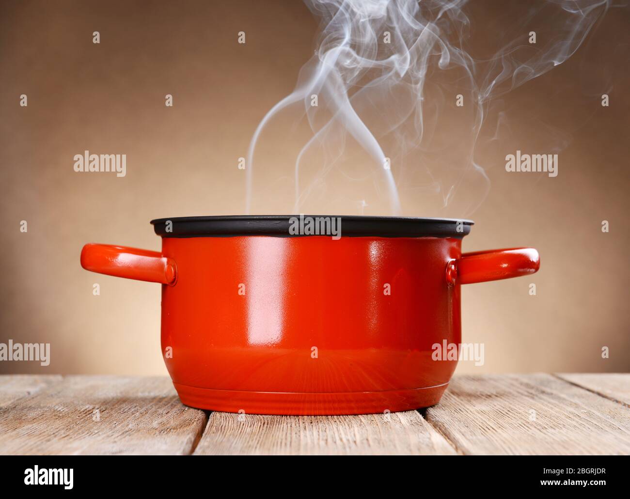 Cooking pot with steam on table on brown background Stock Photo - Alamy