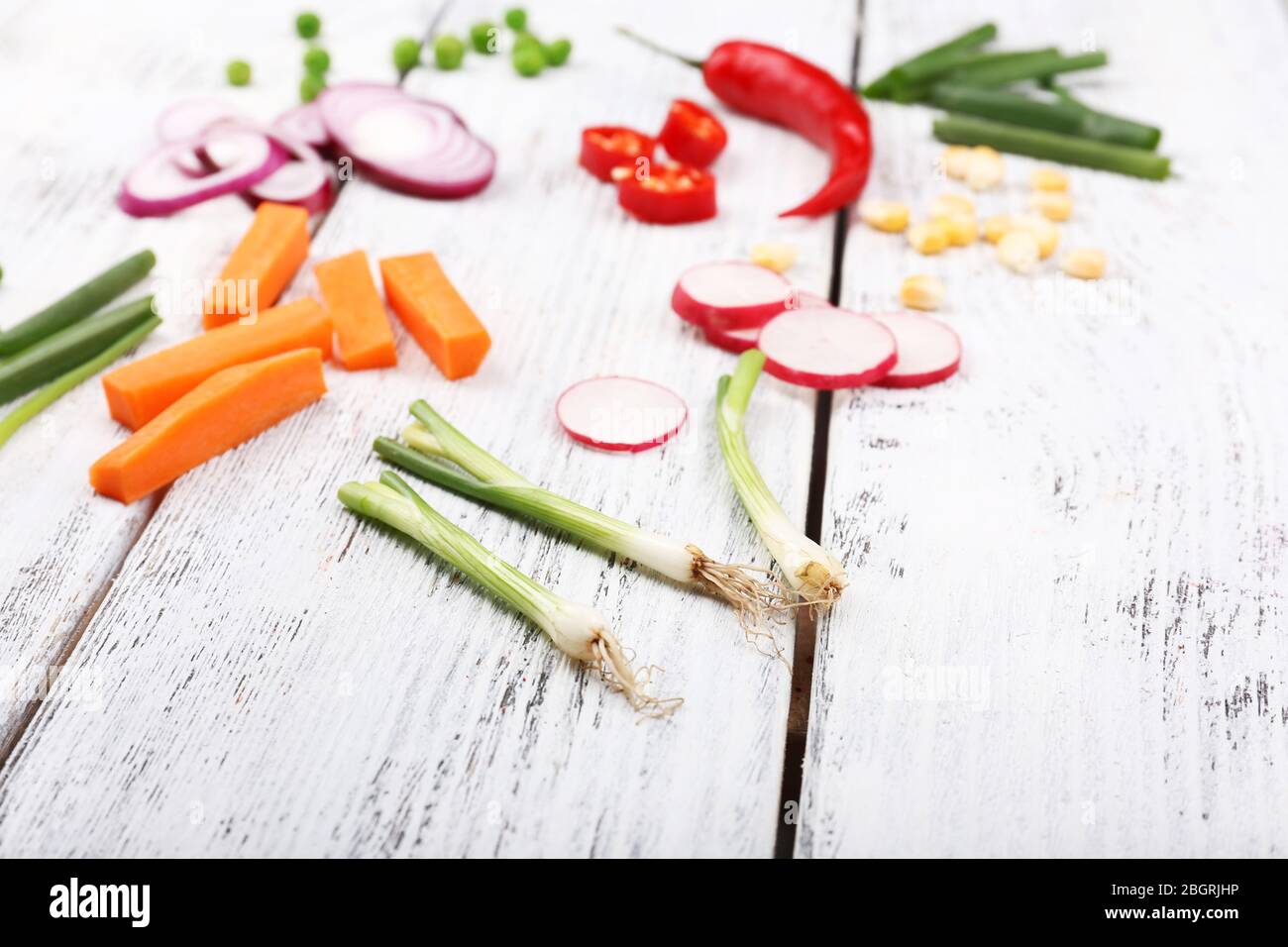 Different kind of raw vegetables on wooden table Stock Photo - Alamy