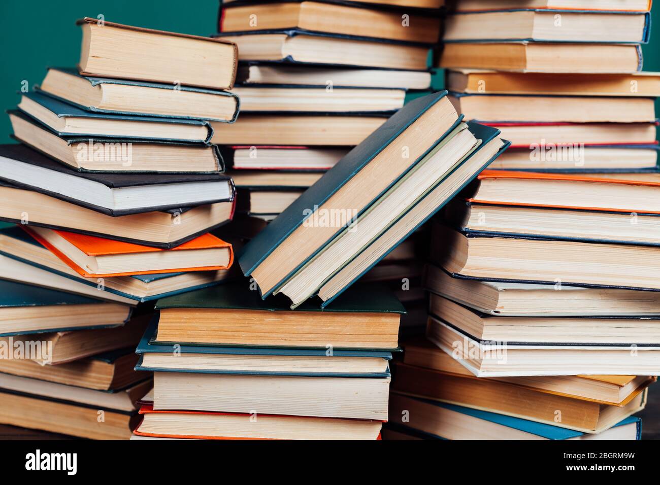 many stacks of educational books in the university library on a green ...