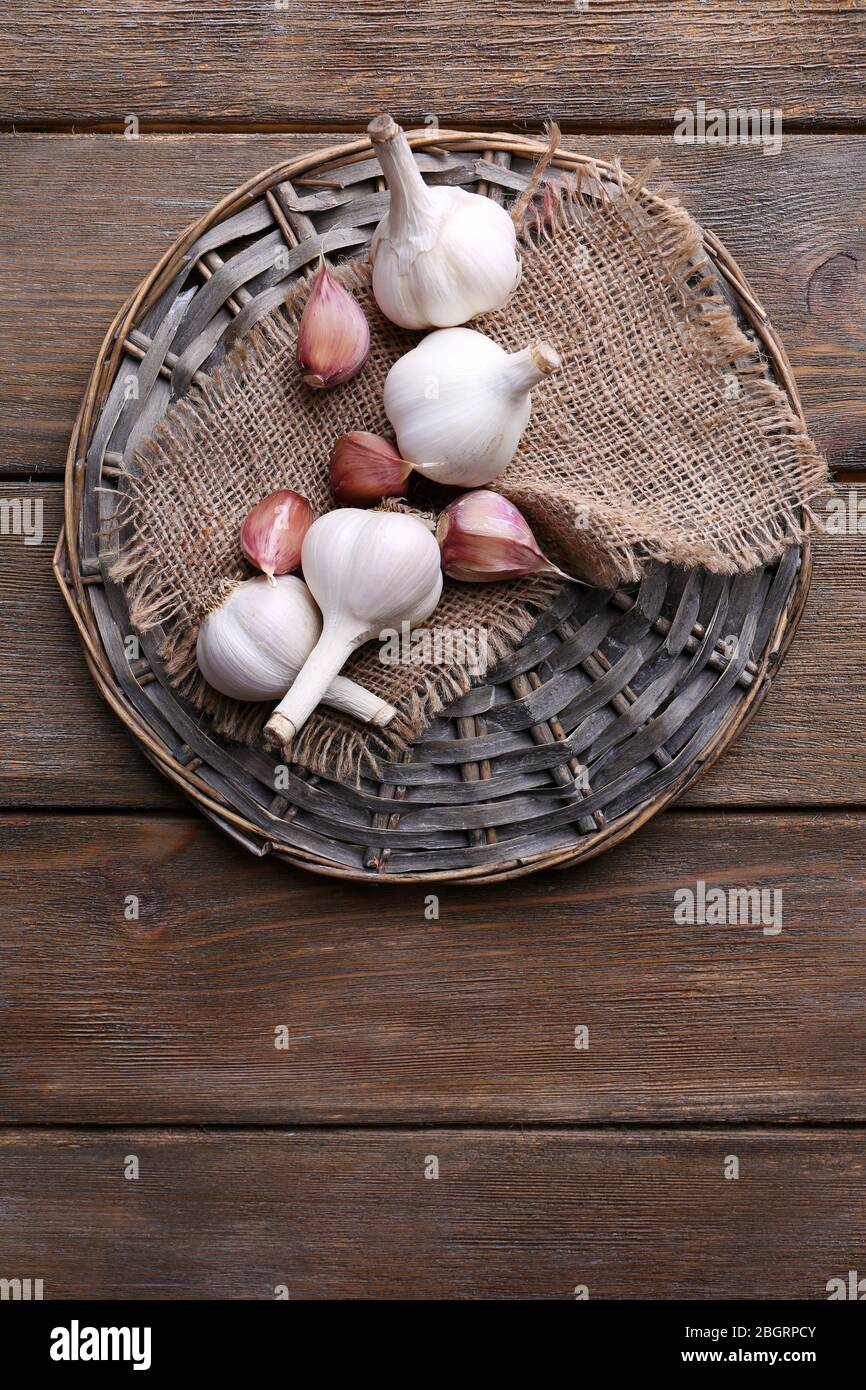 Fresh garlic on wicker mat, on wooden background Stock Photo - Alamy