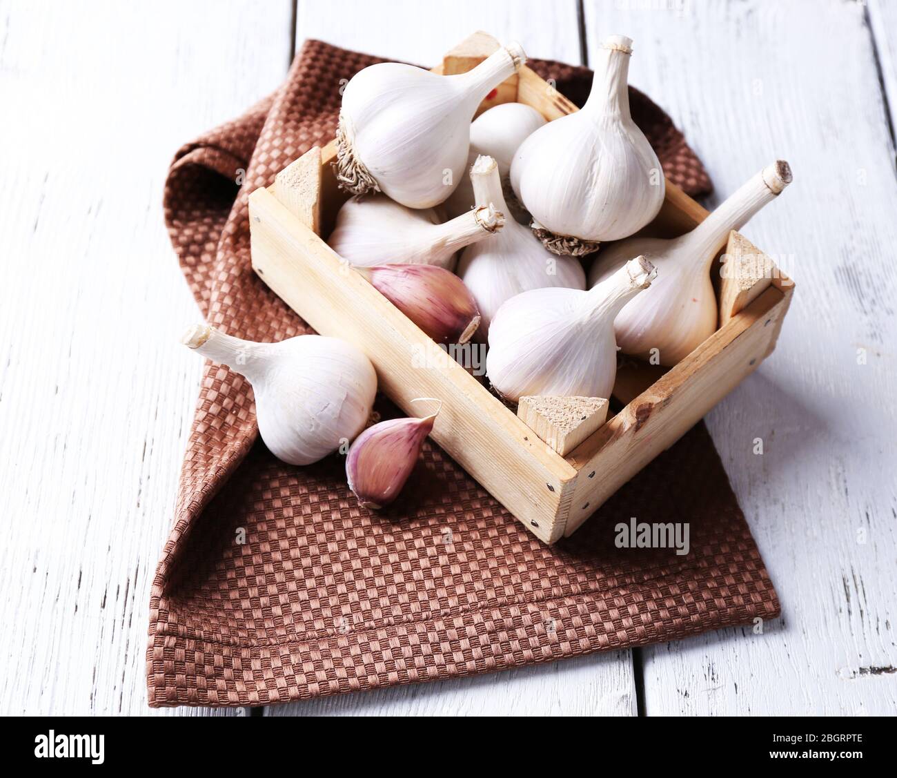 Fresh garlic in box, on wooden background Stock Photo - Alamy