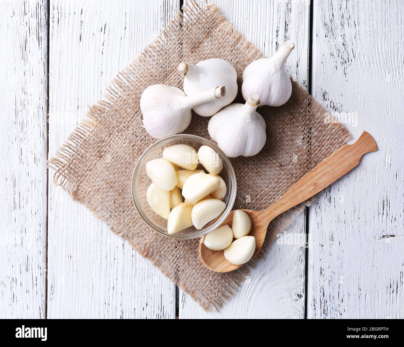 Fresh sliced garlic in glass bowl on wooden background Stock Photo - Alamy