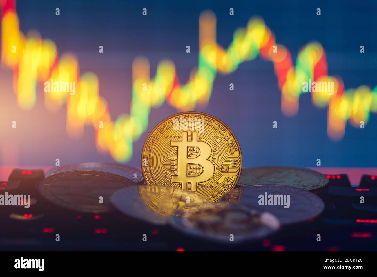 Bitcoin gold coin and defocused chart background. Virtual cryptocurrency concept. Bitcoins on ...