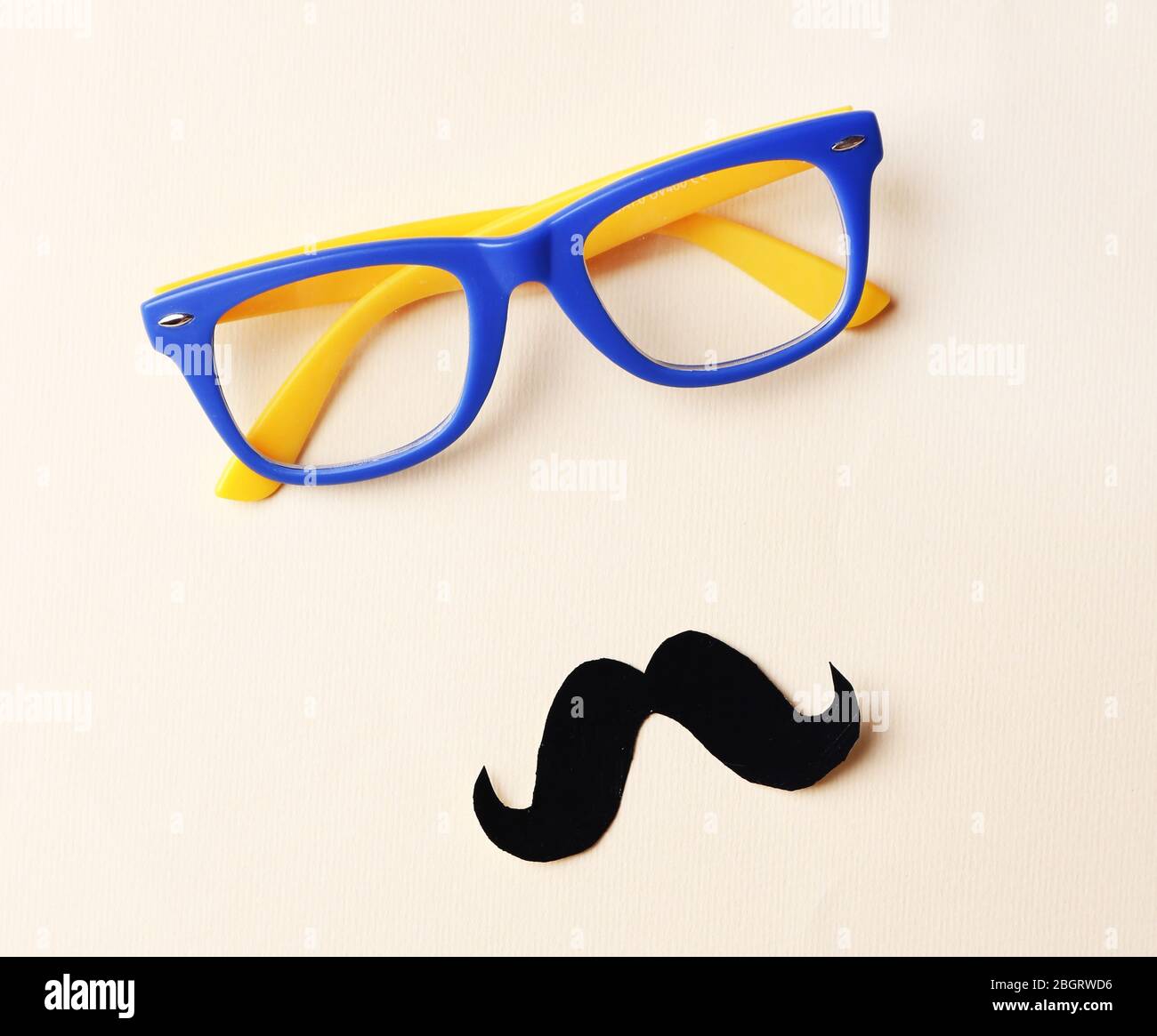 Glasses and mustache forming man face on beige background Stock Photo ...