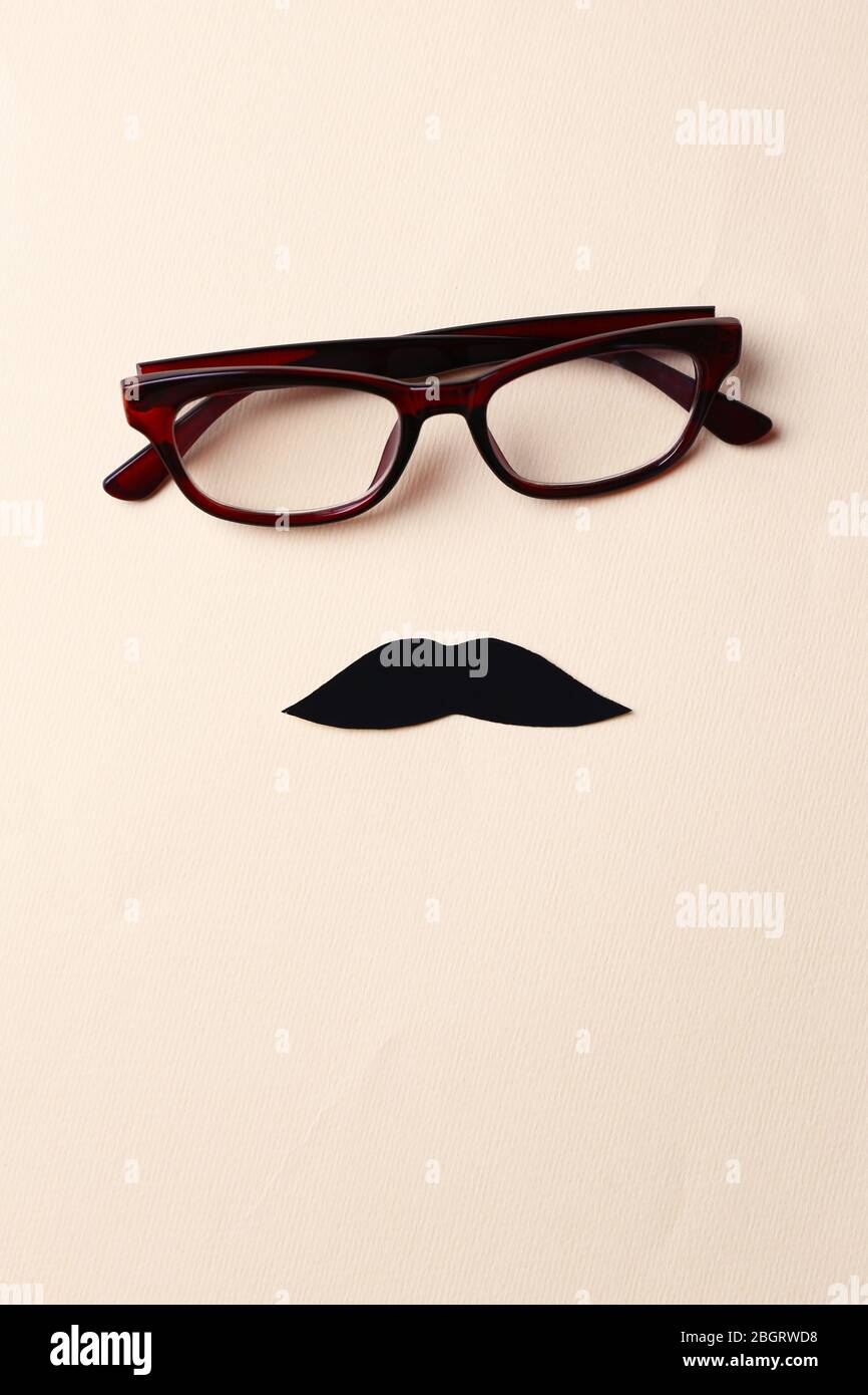 Glasses and mustache forming man face on beige background Stock Photo ...