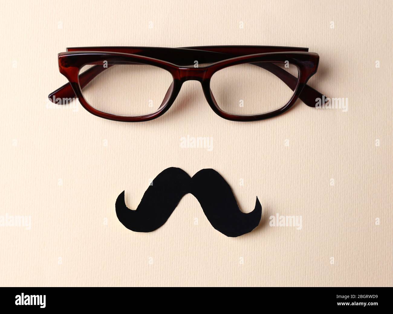 Glasses and mustache forming man face on beige background Stock Photo ...