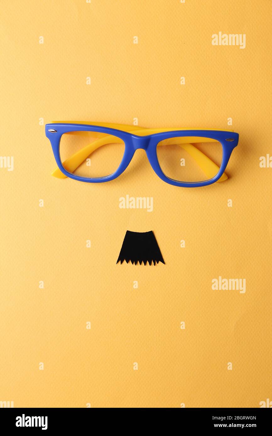 Glasses and mustache forming man face on yellow background Stock Photo ...