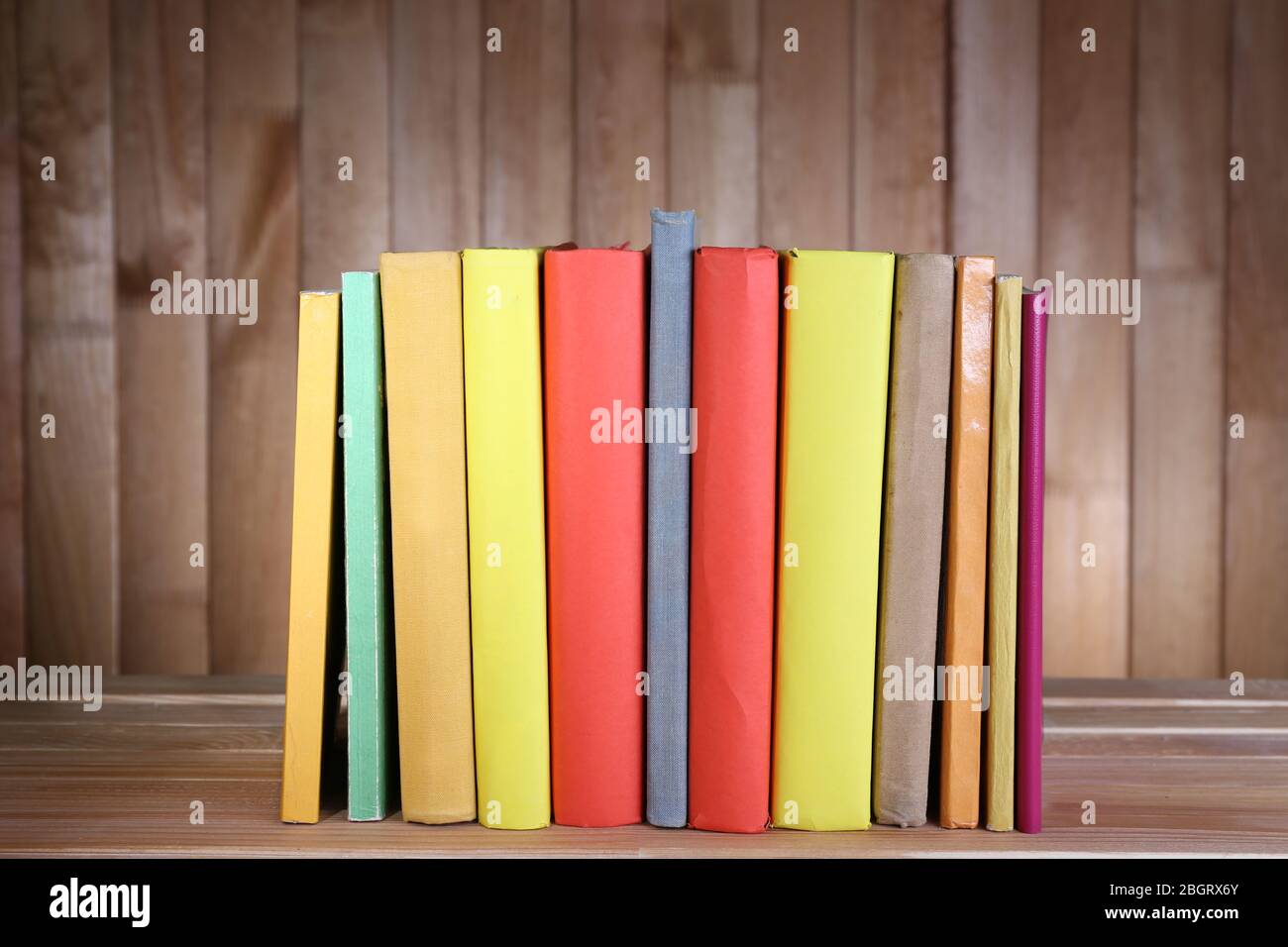 Books on wooden table on wooden wall background Stock Photo - Alamy