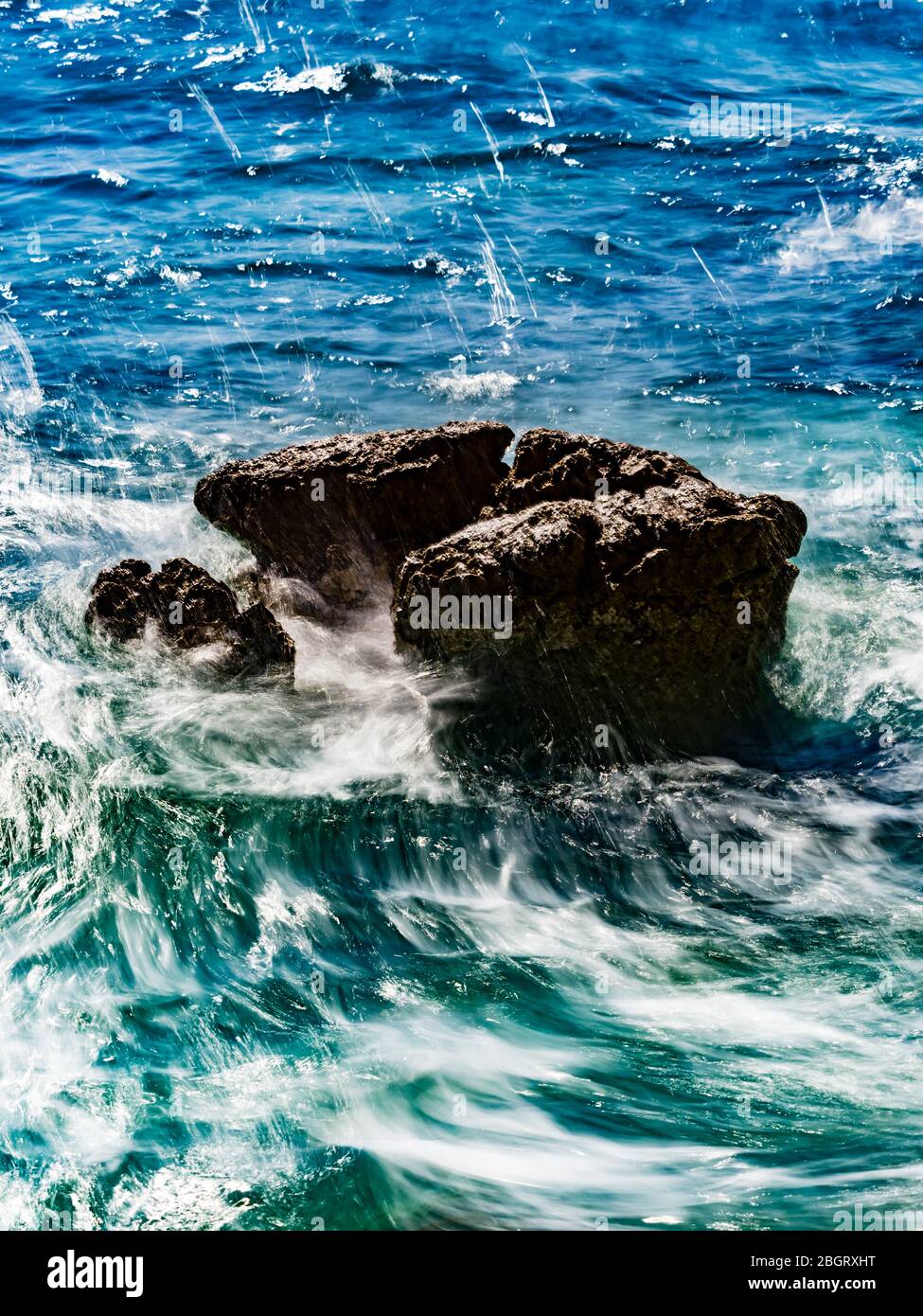 Waves crashing striking shore boulder solitary big rock intentionally ...