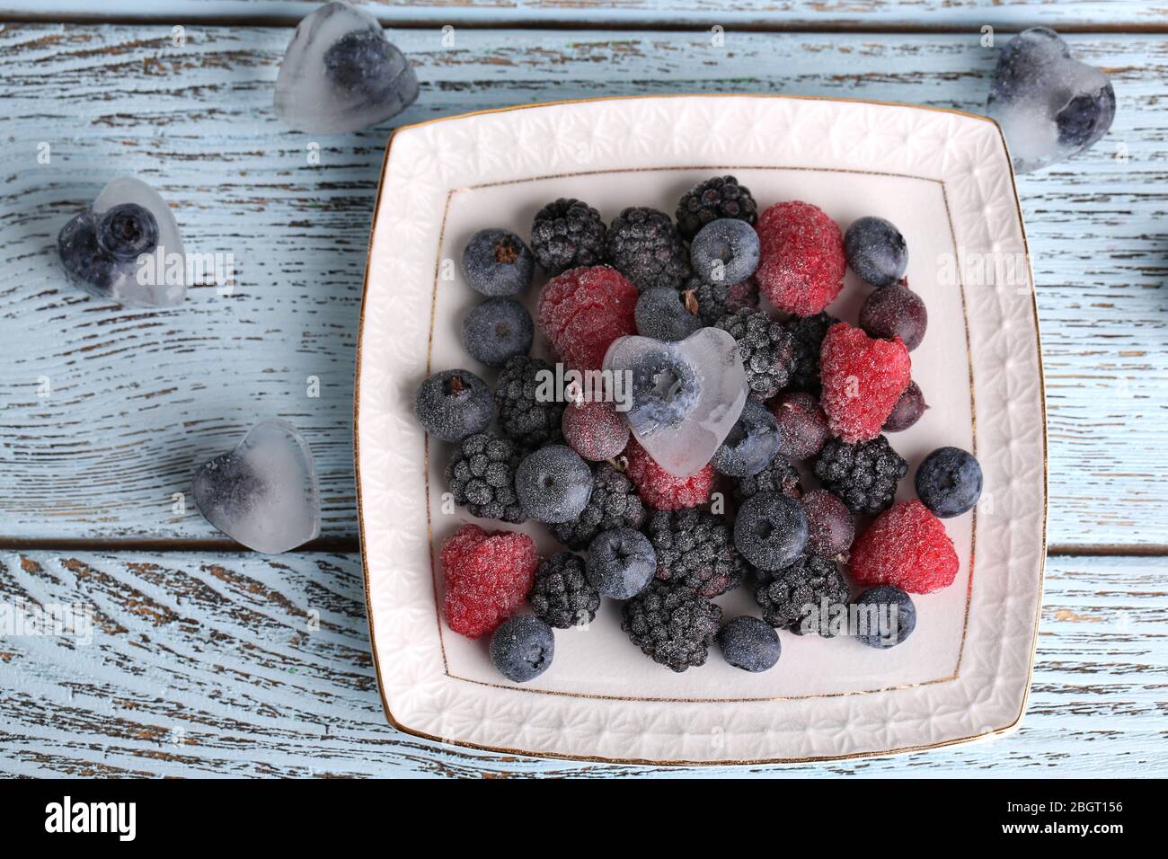 Frozen berries on color wooden background Stock Photo - Alamy
