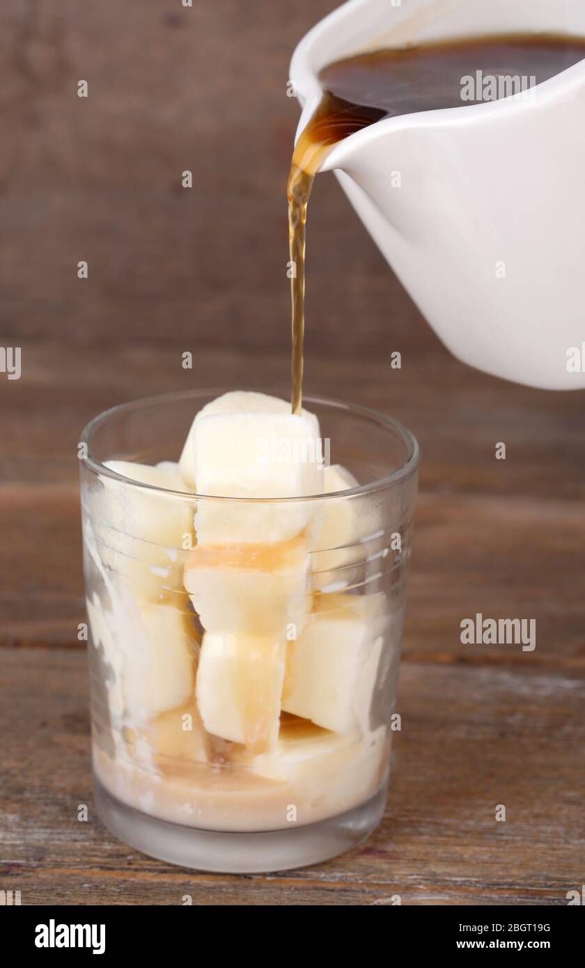 Iced coffee with milky ice cubes in glass on wooden background Stock ...