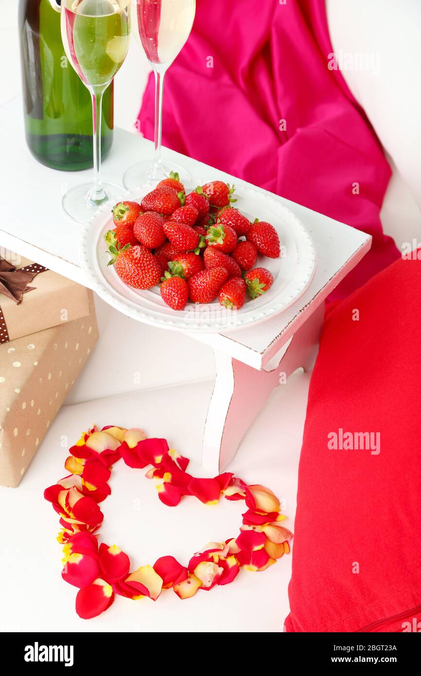 Romantic still life with champagne, strawberry and roses on sofa Stock ...