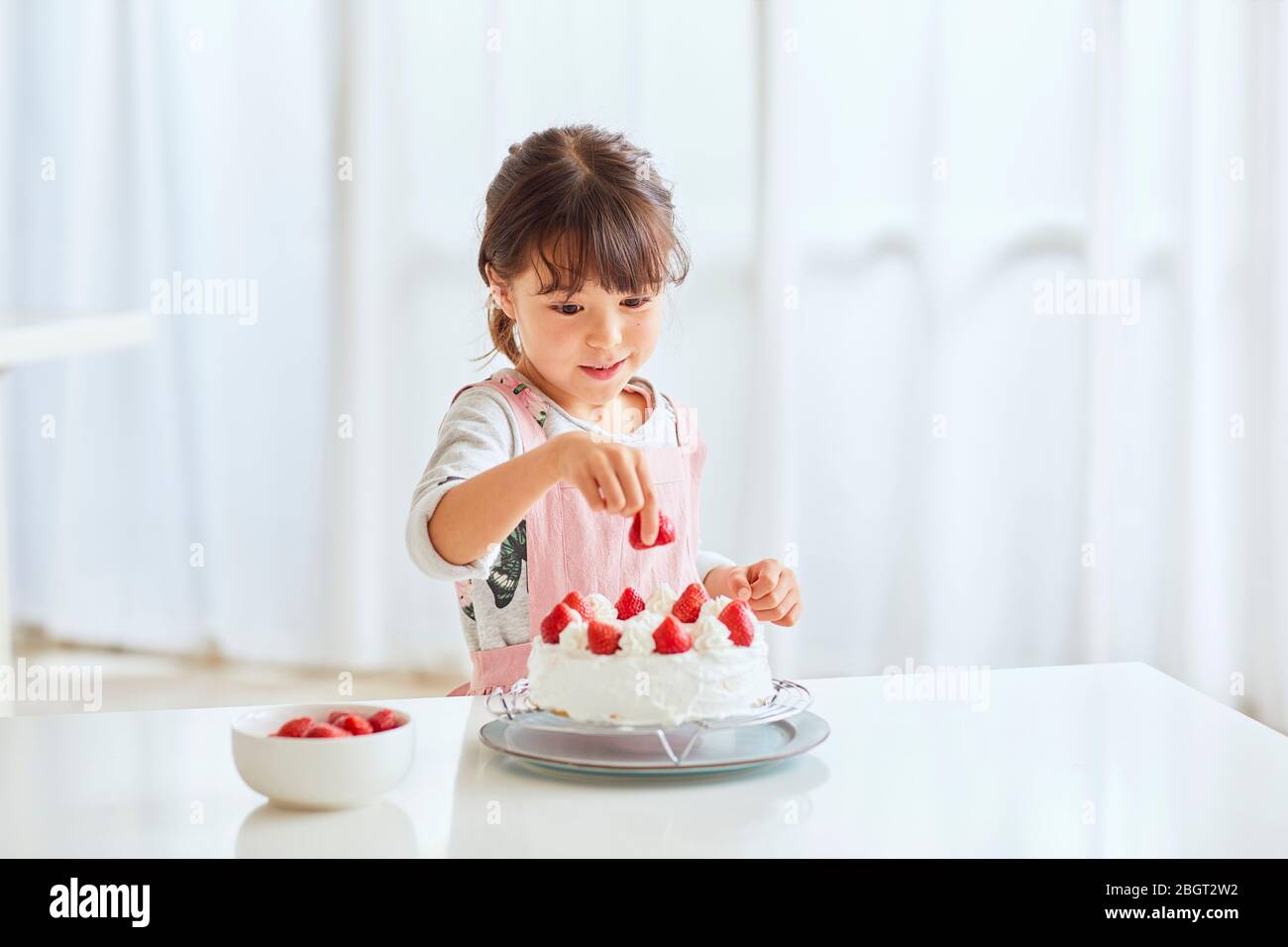 Young happy girl preparing a cake in the kitchen Stock Photo - Alamy