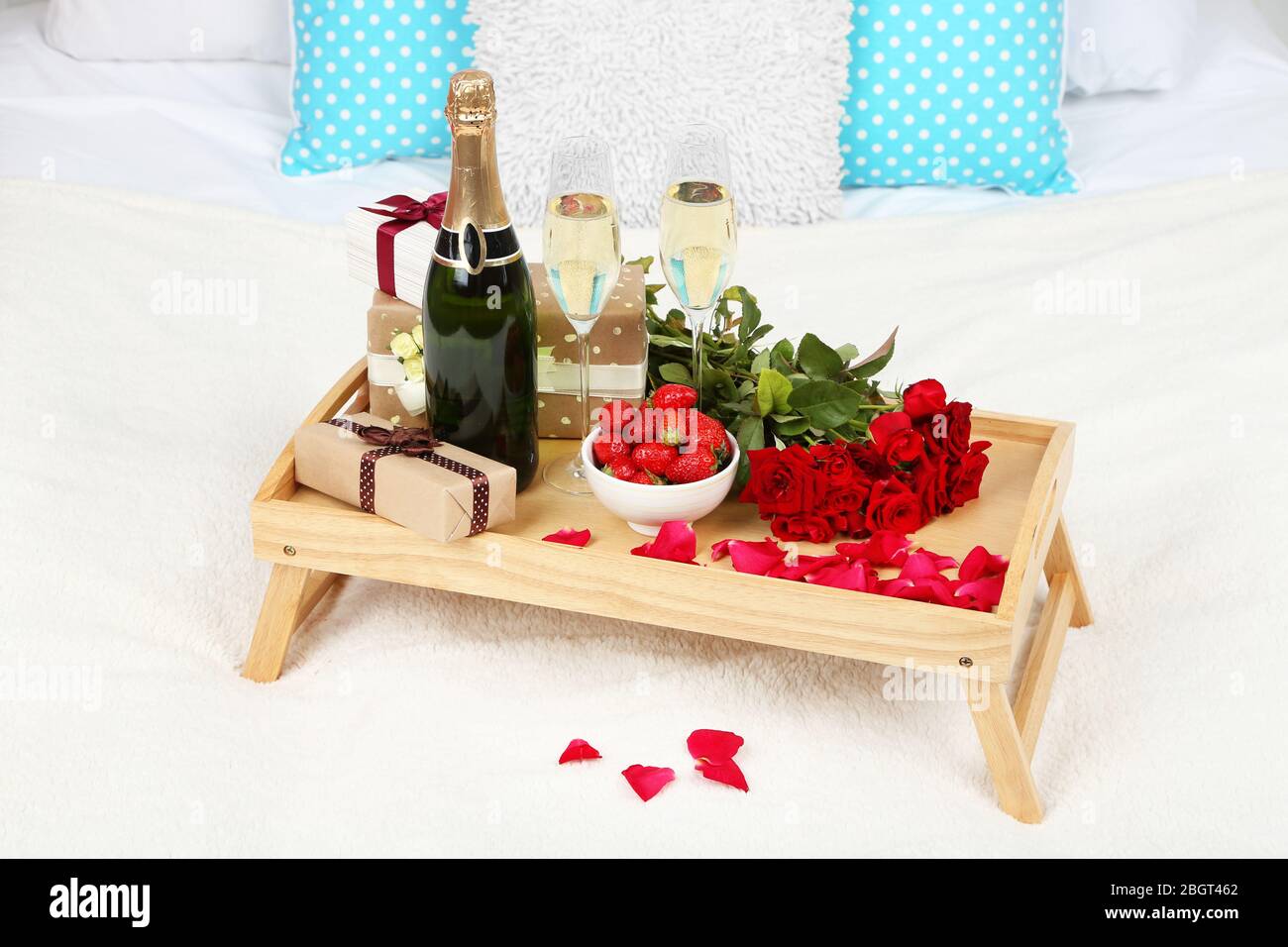 Romantic still life with champagne, strawberry and roses on bed Stock ...