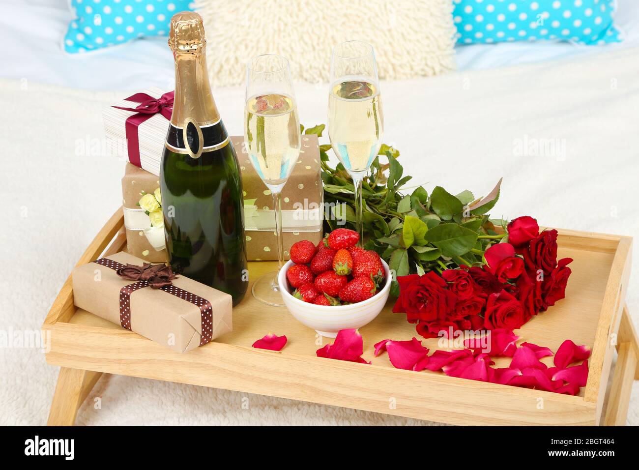Romantic still life with champagne, strawberry and roses on bed Stock ...