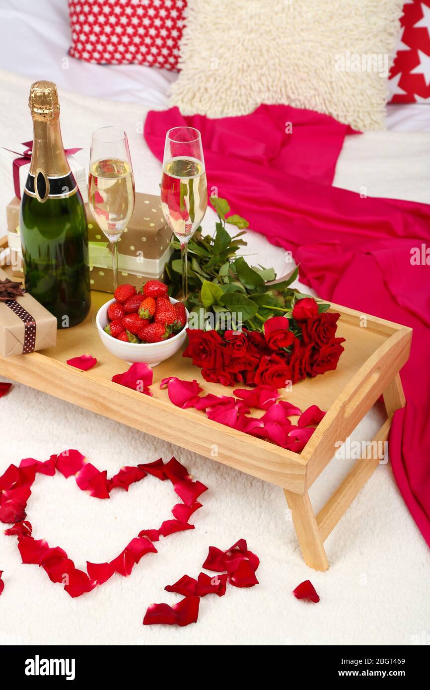 Romantic still life with champagne, strawberry and roses on bed Stock ...