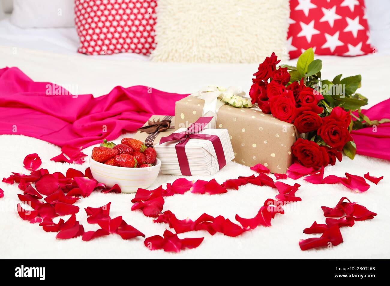 Romantic still life with strawberry, gift boxes and petals of roses on ...