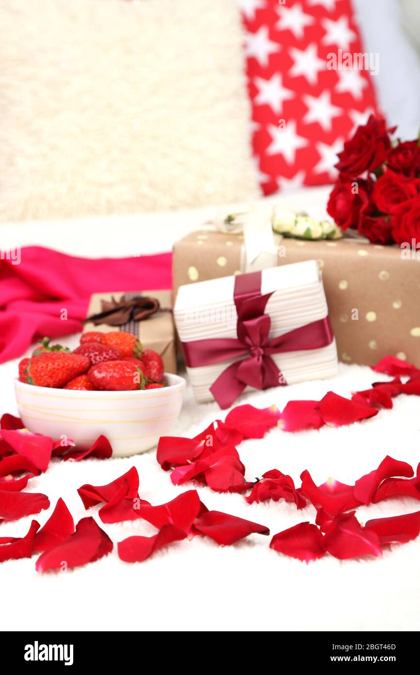Romantic still life with strawberry, gift boxes and petals of roses on ...