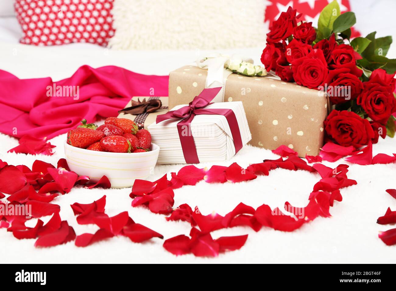 Romantic still life with strawberry, gift boxes and petals of roses on ...