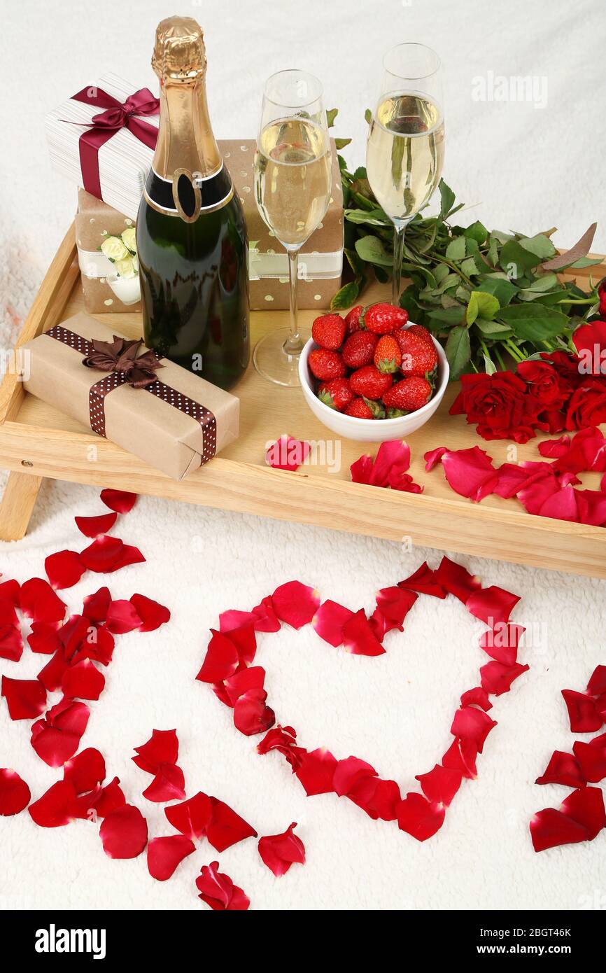 Romantic still life with champagne, strawberry and roses on bed Stock ...