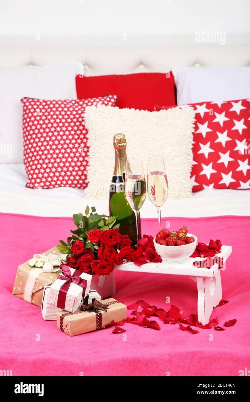 Romantic still life with champagne, strawberry and roses on bed Stock ...