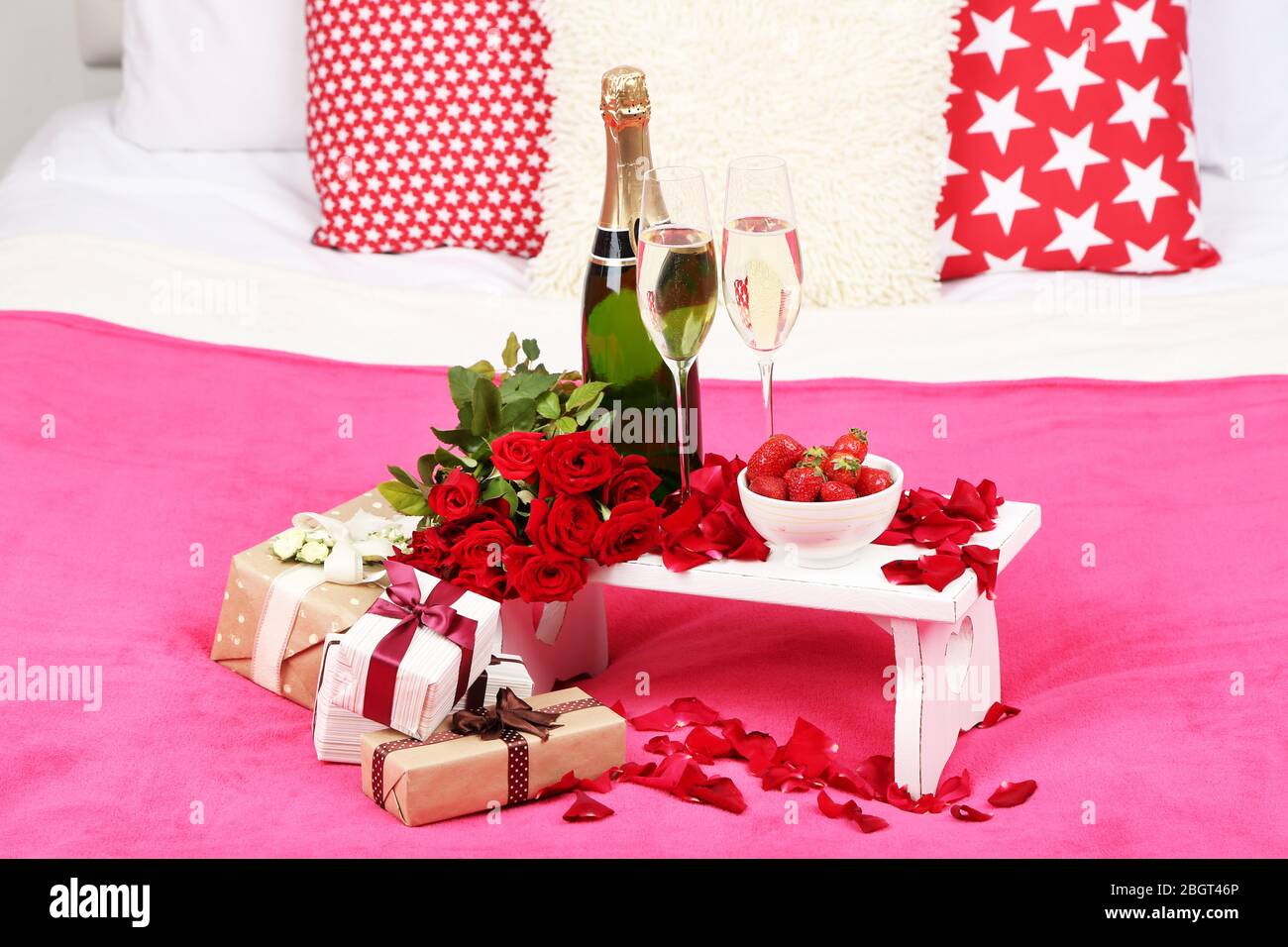 Romantic still life with champagne, strawberry and roses on bed Stock ...