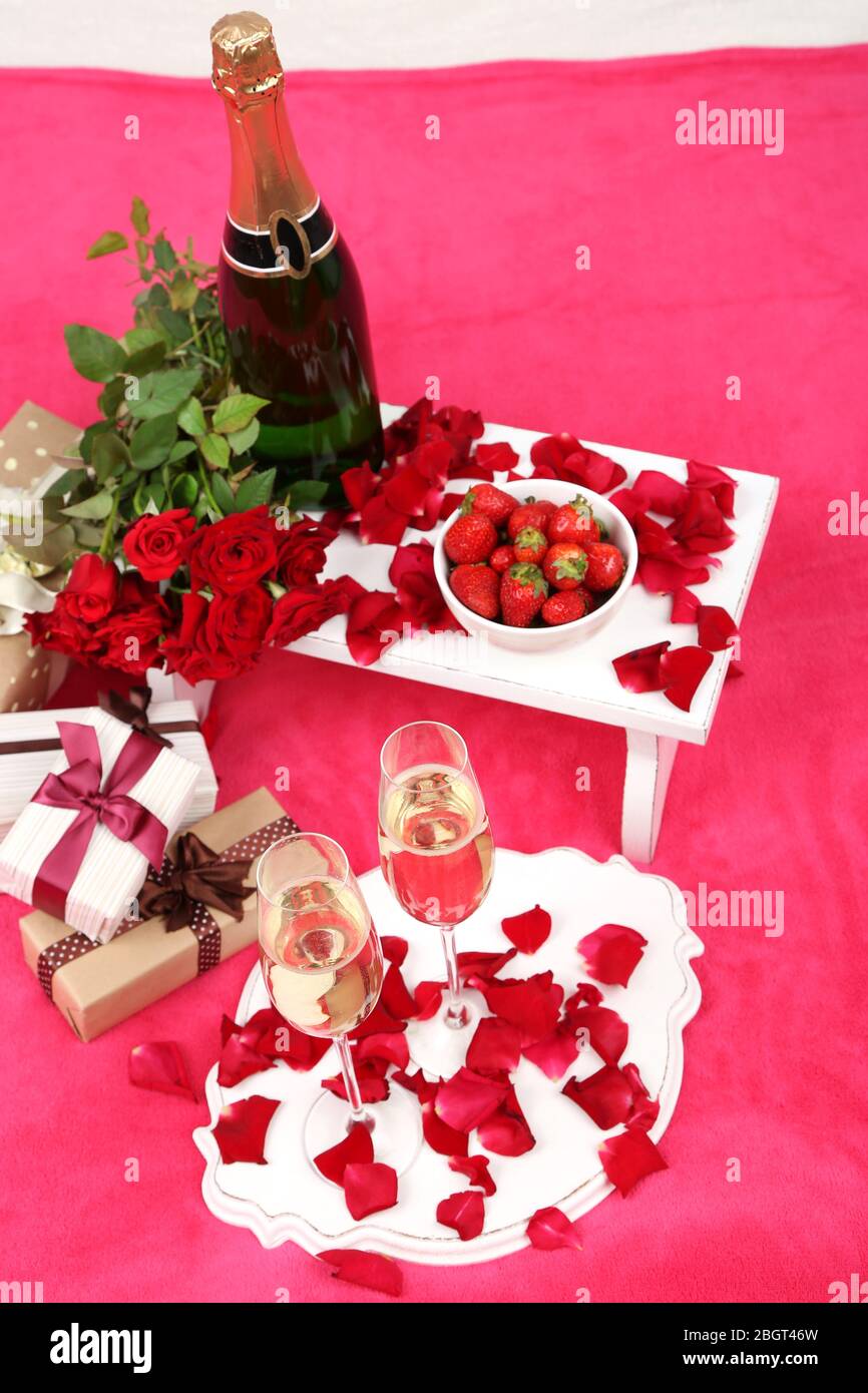 Romantic still life with champagne, strawberry and roses on bed Stock ...