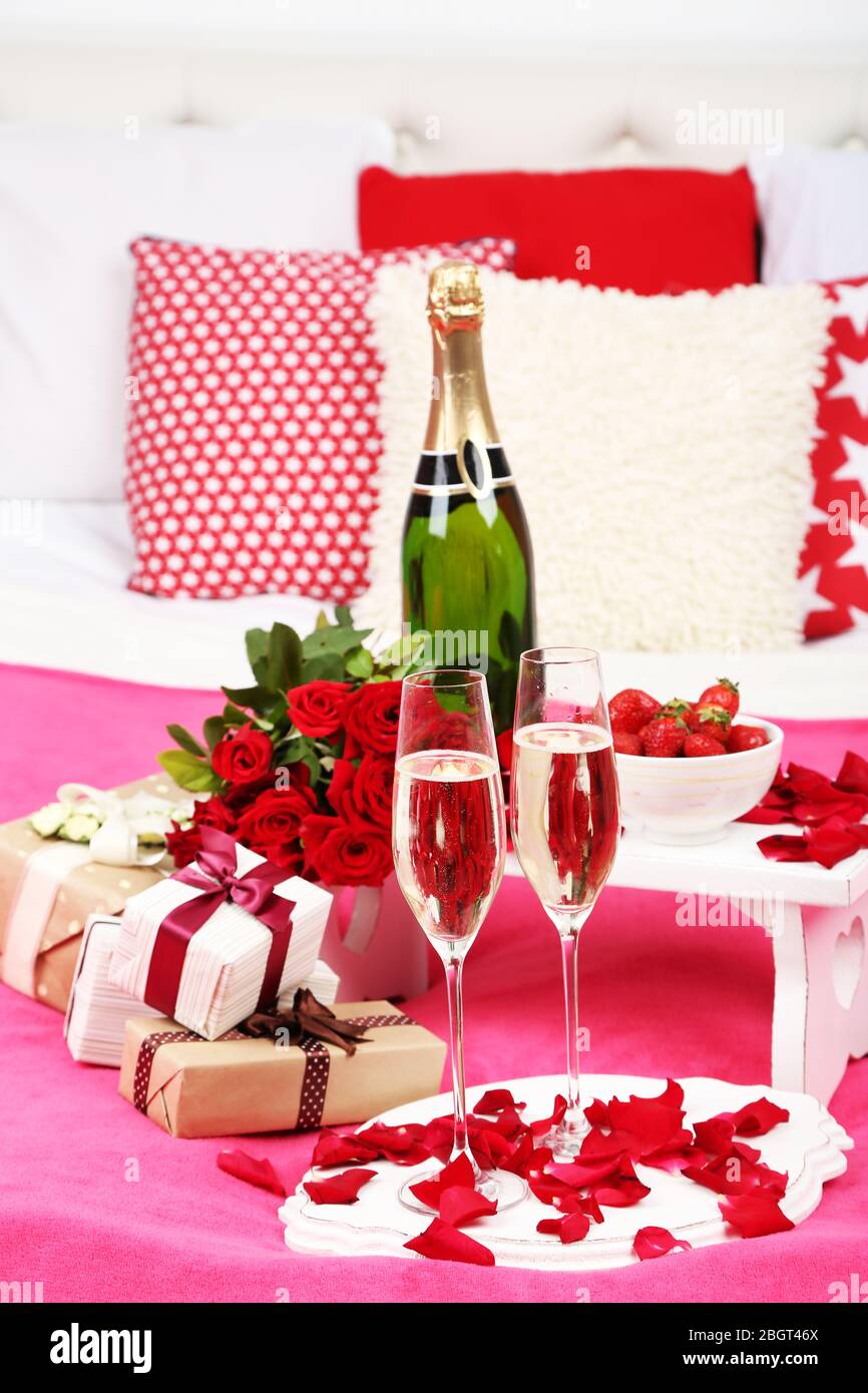 Romantic still life with champagne, strawberry and roses on bed Stock ...