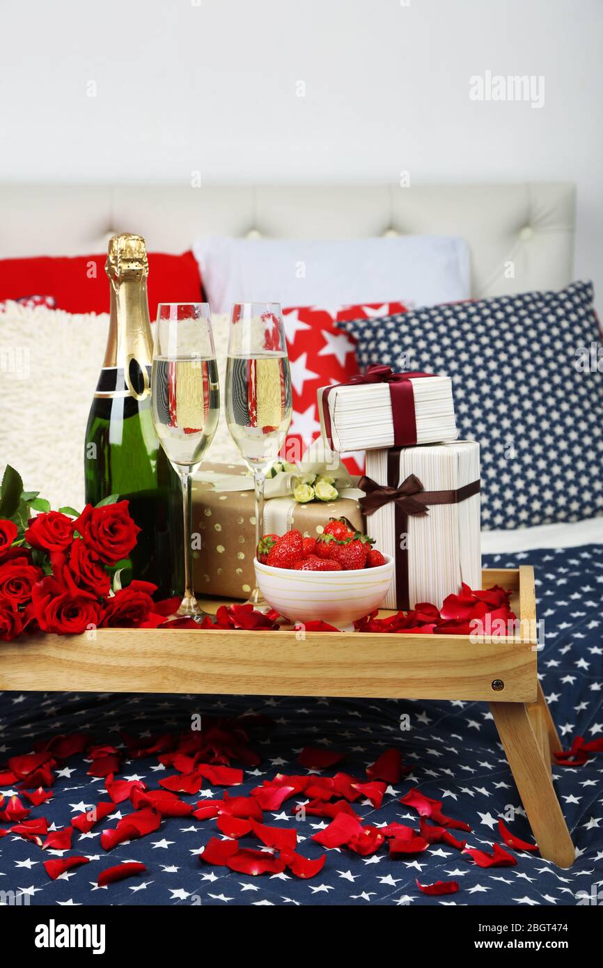Romantic still life with champagne, strawberry and roses on bed Stock ...