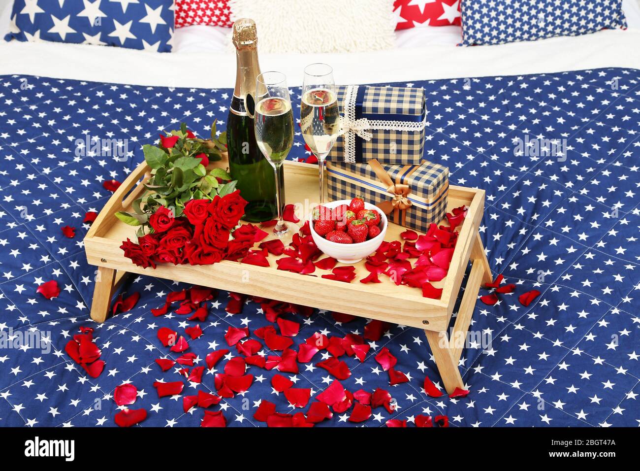 Romantic still life with champagne, strawberry and roses on bed Stock ...