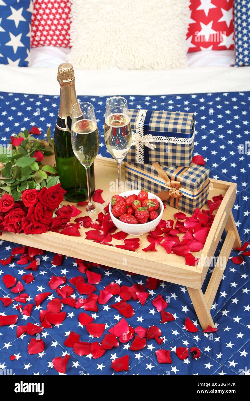 Romantic still life with champagne, strawberry and roses on bed Stock ...