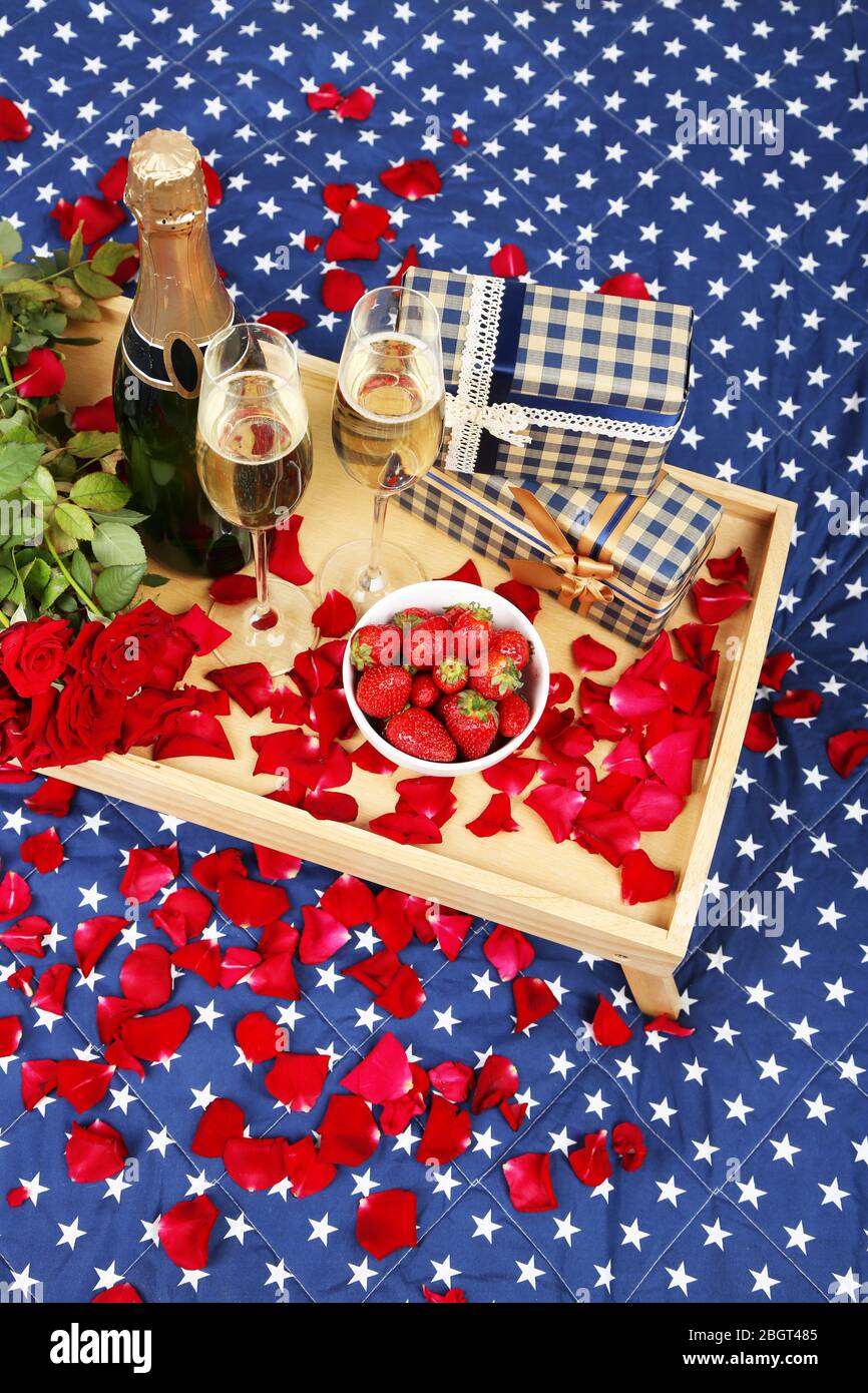 Romantic still life with champagne, strawberry and roses on bed Stock ...