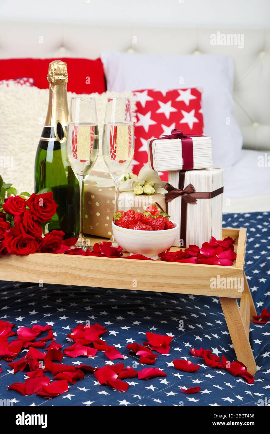 Romantic still life with champagne, strawberry and roses on bed Stock ...