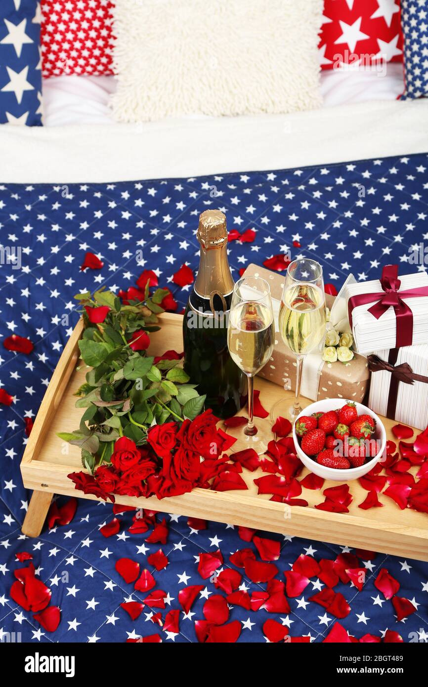 Romantic still life with champagne, strawberry and roses on bed Stock ...