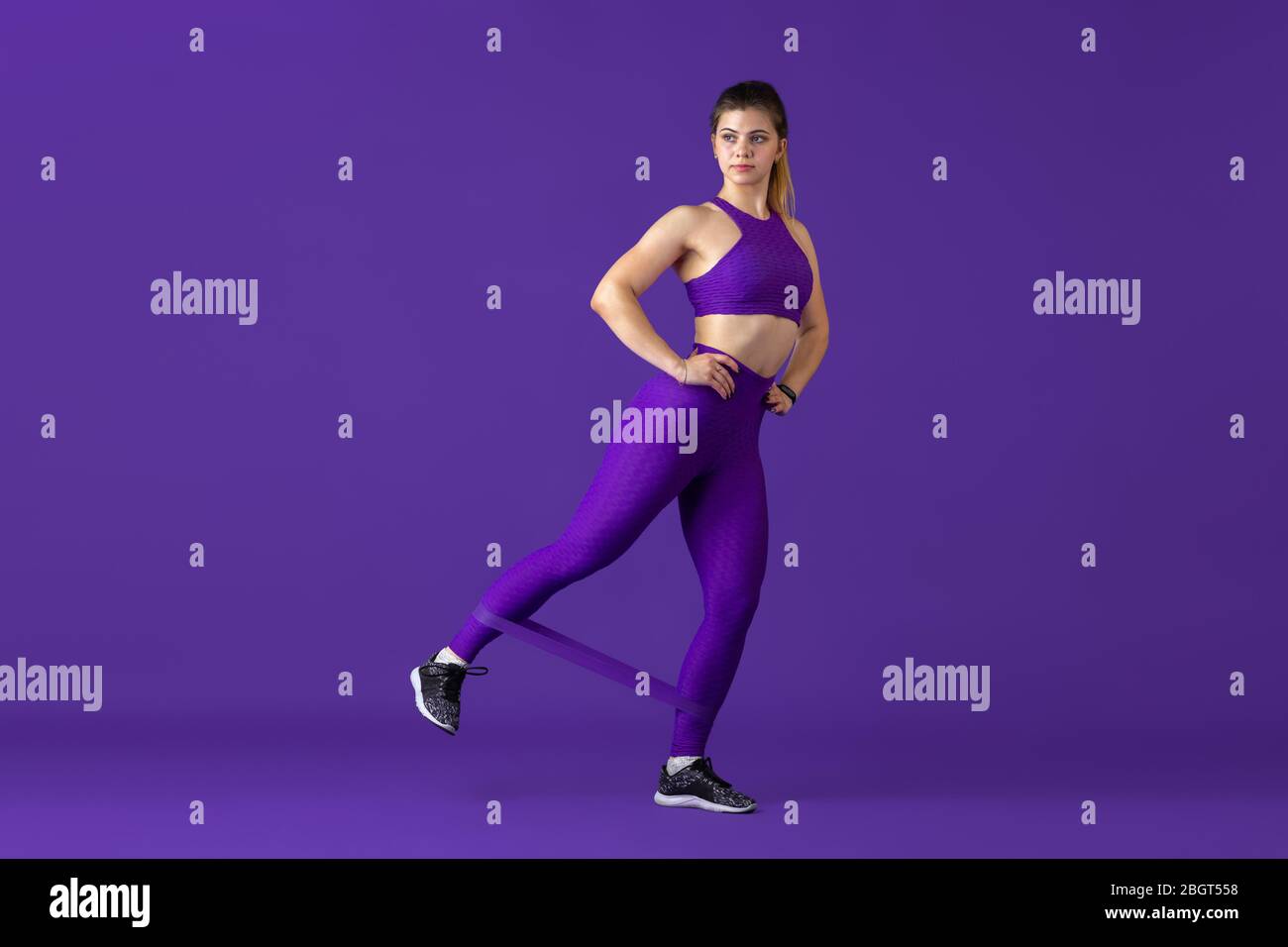 Strong. Beautiful young female athlete practicing in studio, monochrome ...