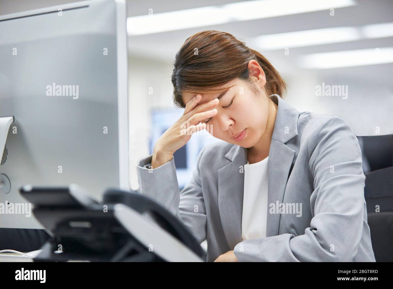 Tired Japanese businesswoman in the office Stock Photo - Alamy