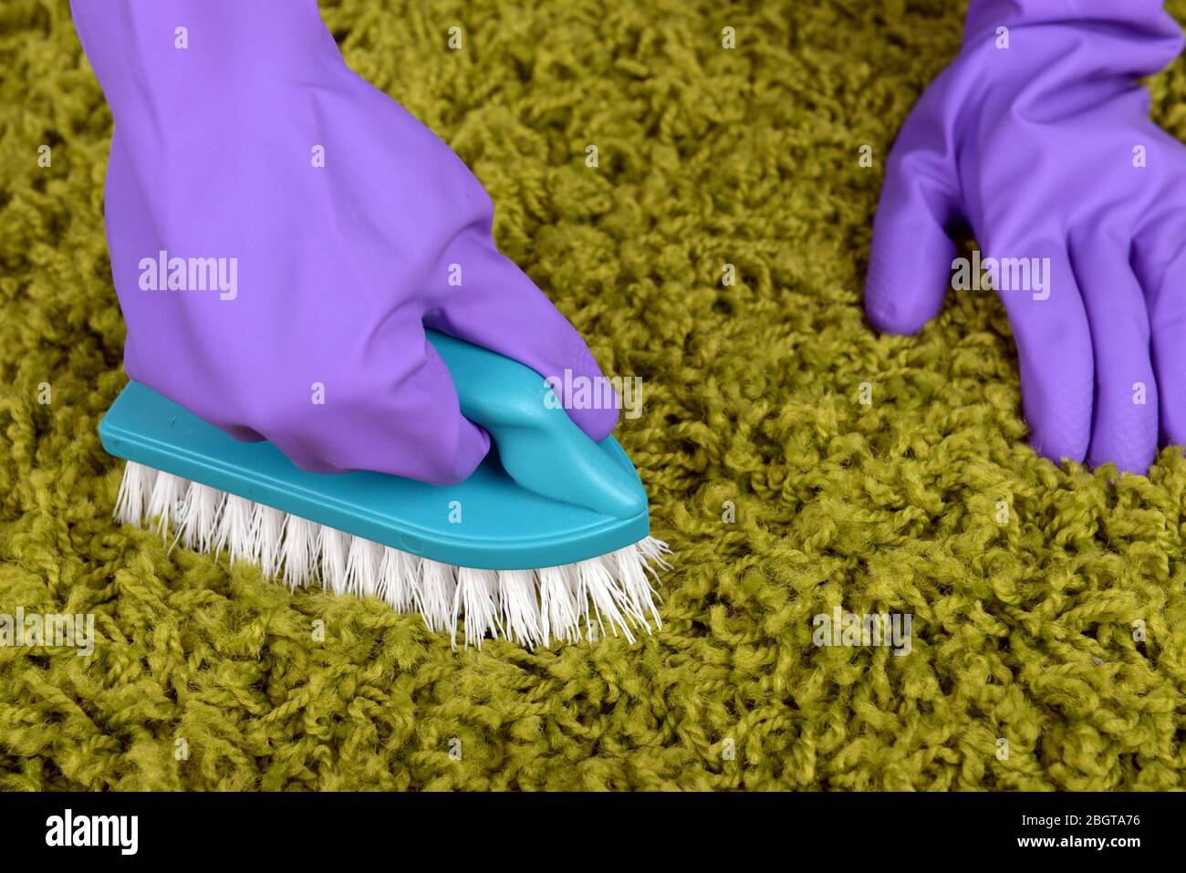 Cleaning carpet with brush close up Stock Photo - Alamy