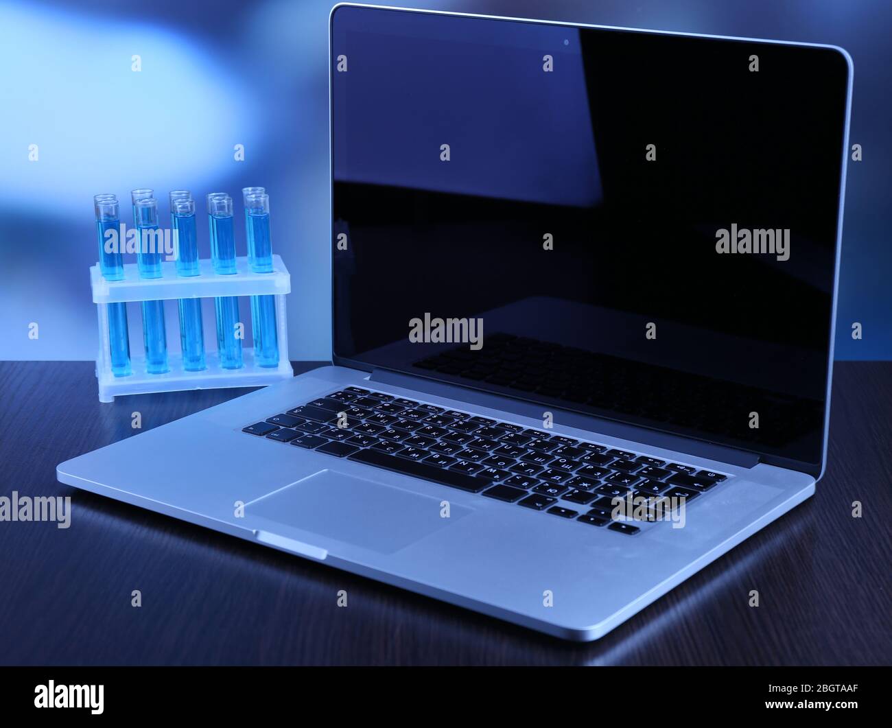 Laptop with test tubes in a laboratory on blue background Stock Photo ...