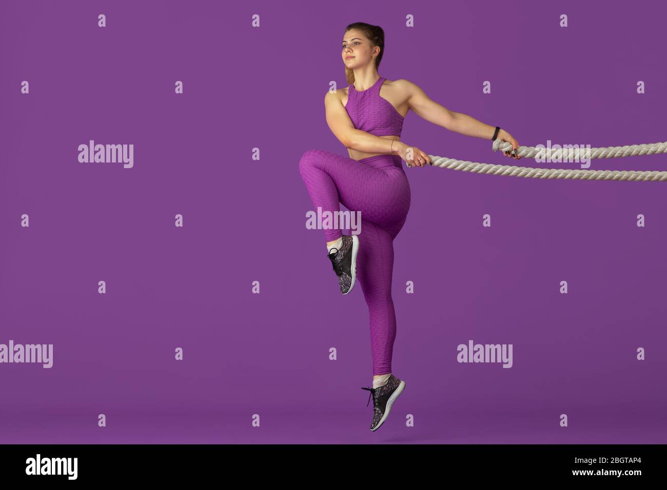 In jump. Beautiful young female athlete practicing in studio ...