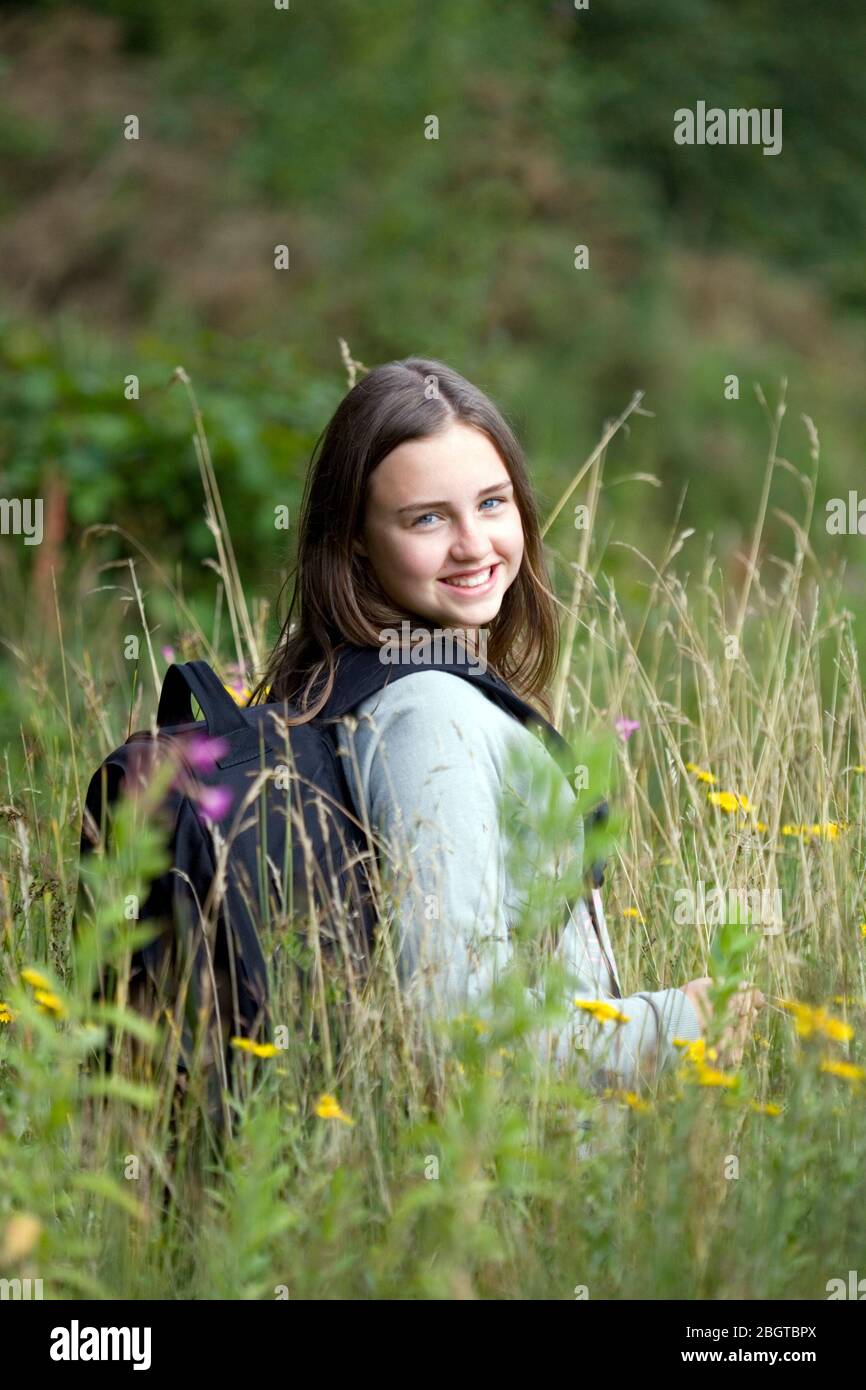 Girl with rucksack, smiling in an English meadow. Lancashire, August ...