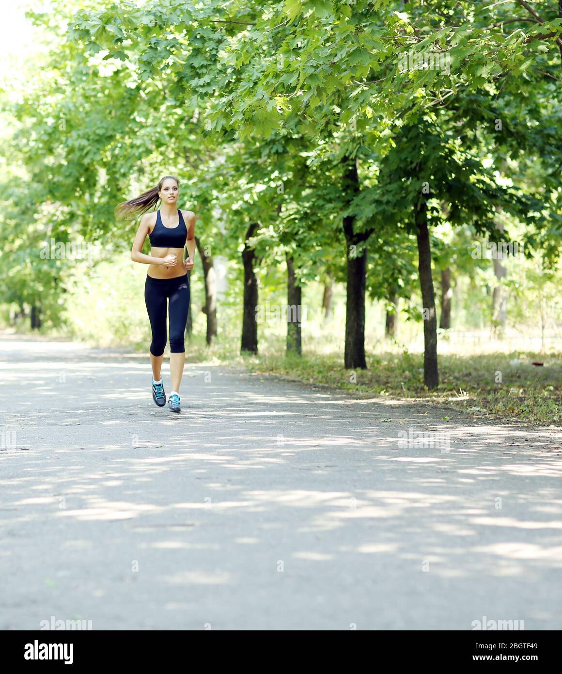 Young woman jogging at park Stock Photo - Alamy