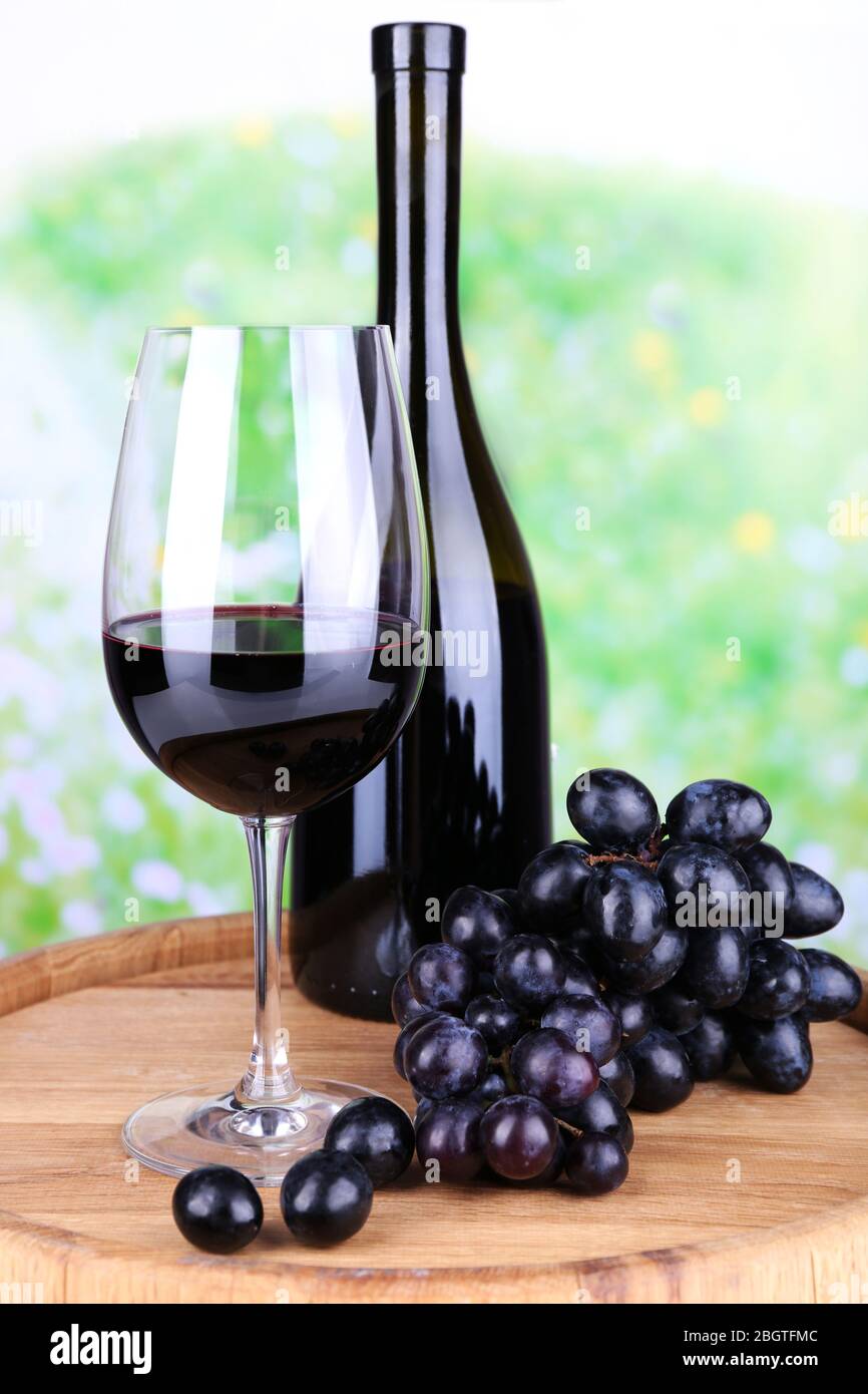 Tasty wine and ripe grape on green nature background Stock Photo - Alamy