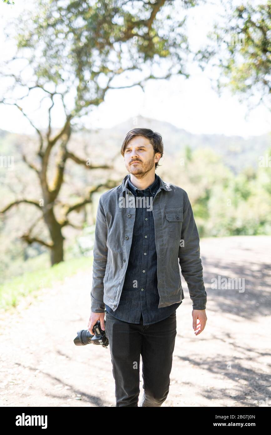 Young man hiking outdoors with camera in Northern California Stock ...