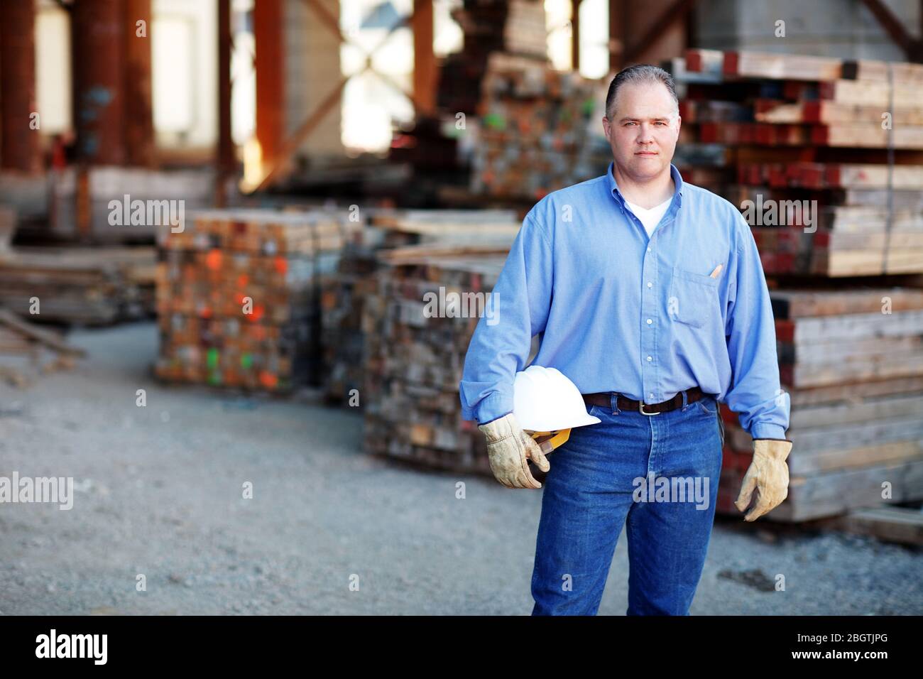Construction worker holding hard hat hi-res stock photography and ...