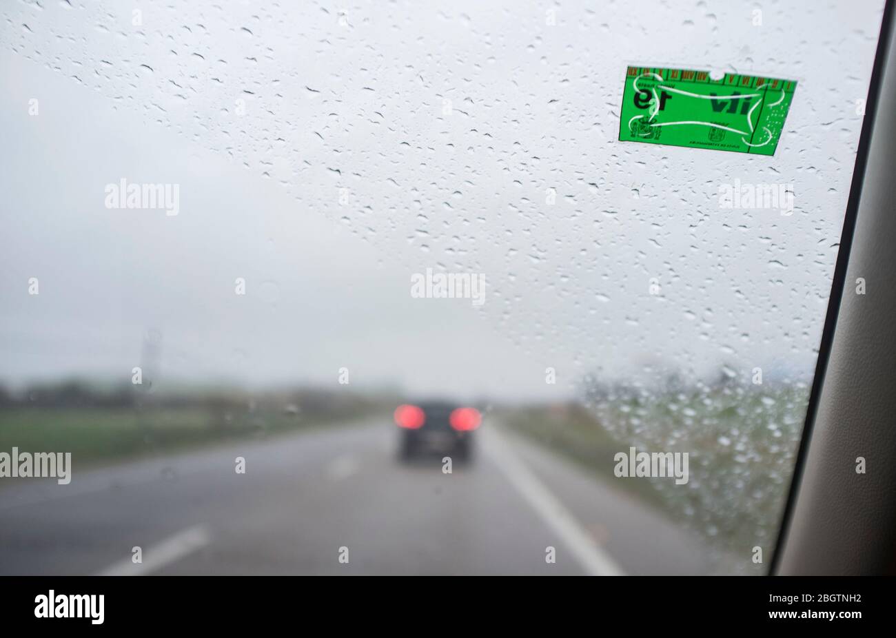 Vehicule Inspection Sticker of on windscreen a rainy day. View from the ...