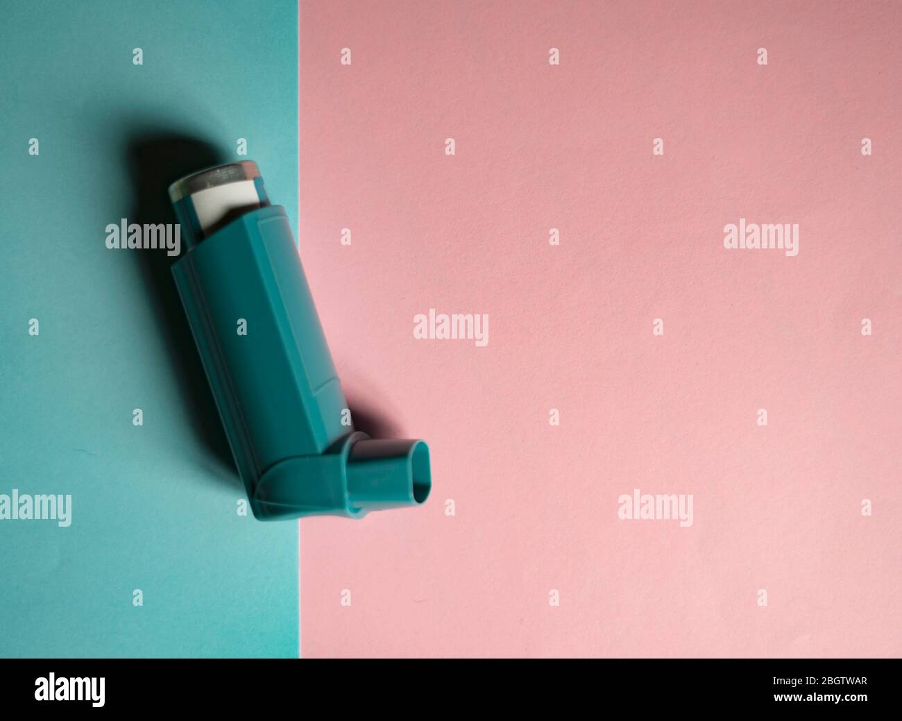 Blue asthma inhaler on a pink and blue background. Asthma and inhaler ...