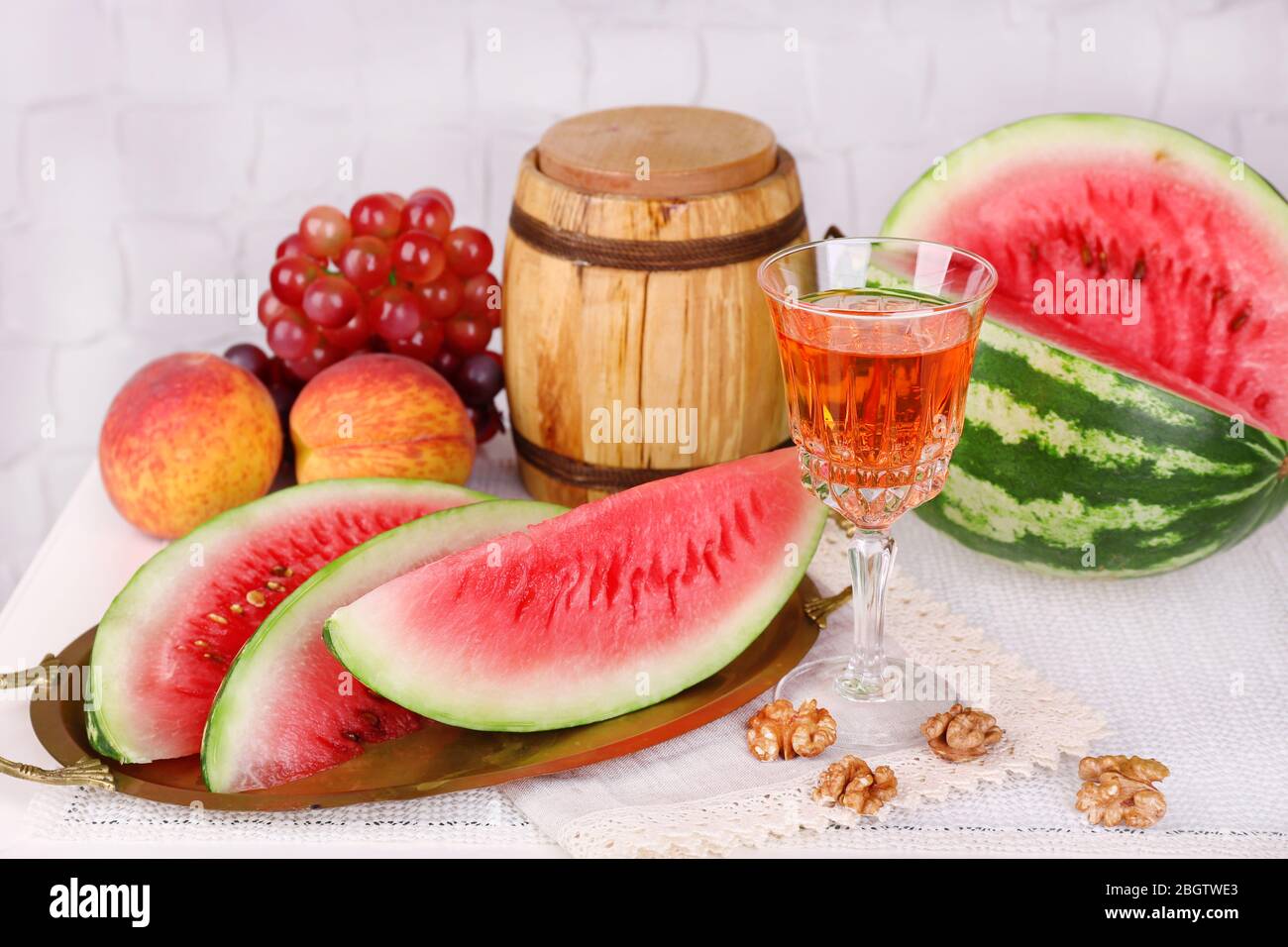 Composition of ripe watermelon, fruits, pink wine in glass and wooden ...