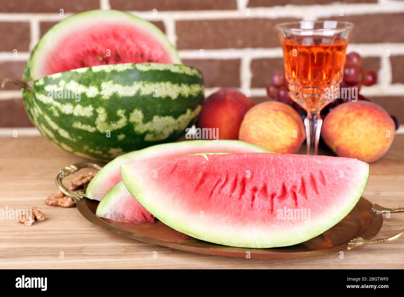 Composition of ripe watermelon, fruits, pink wine in glass and wooden ...